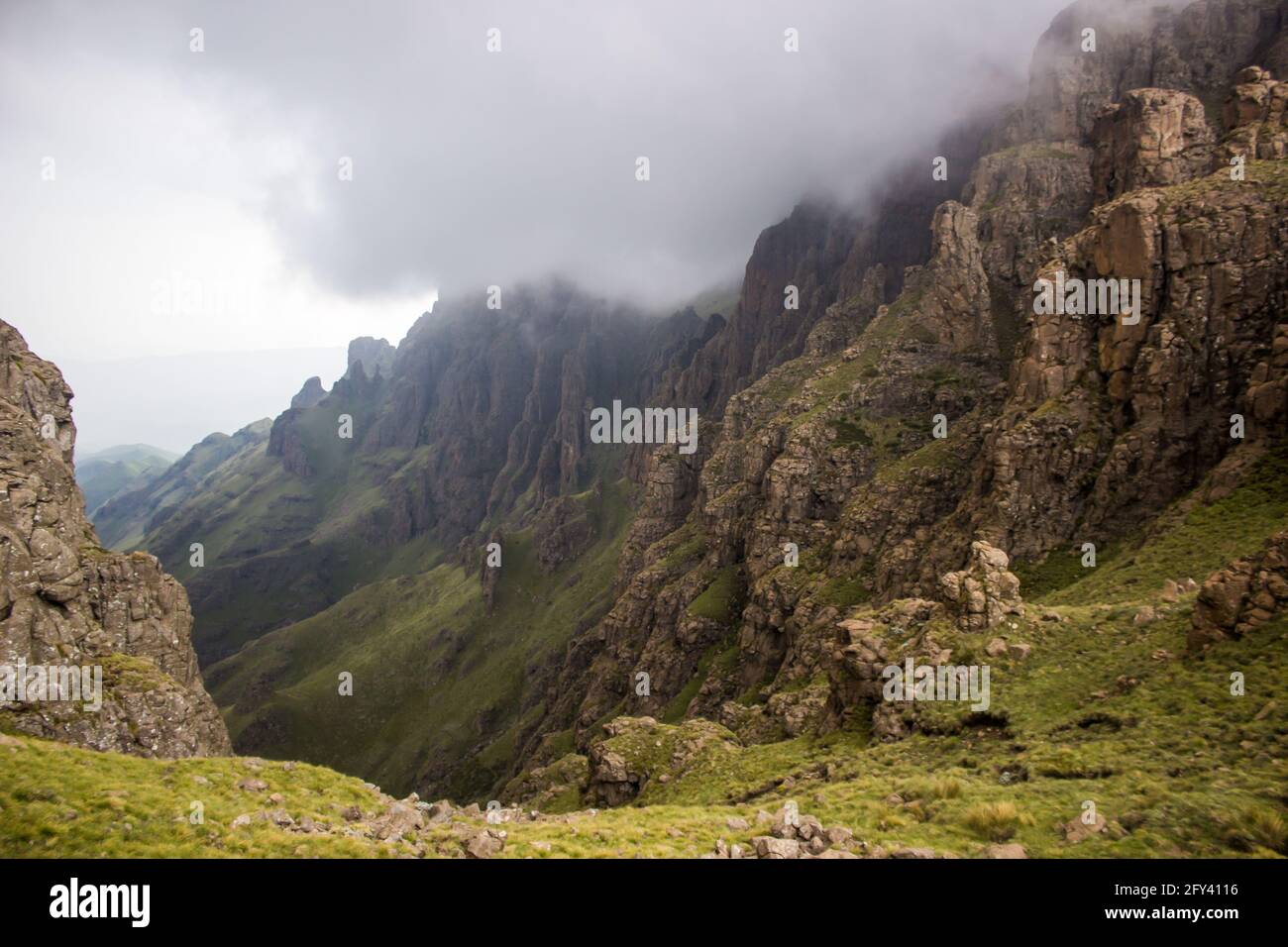 Fog descending along the jagged, weathered basalt cliffs next to the ...