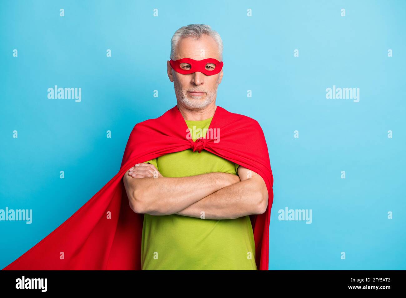 Portrait of attractive serious grey-haired superman folded arms cloak ...
