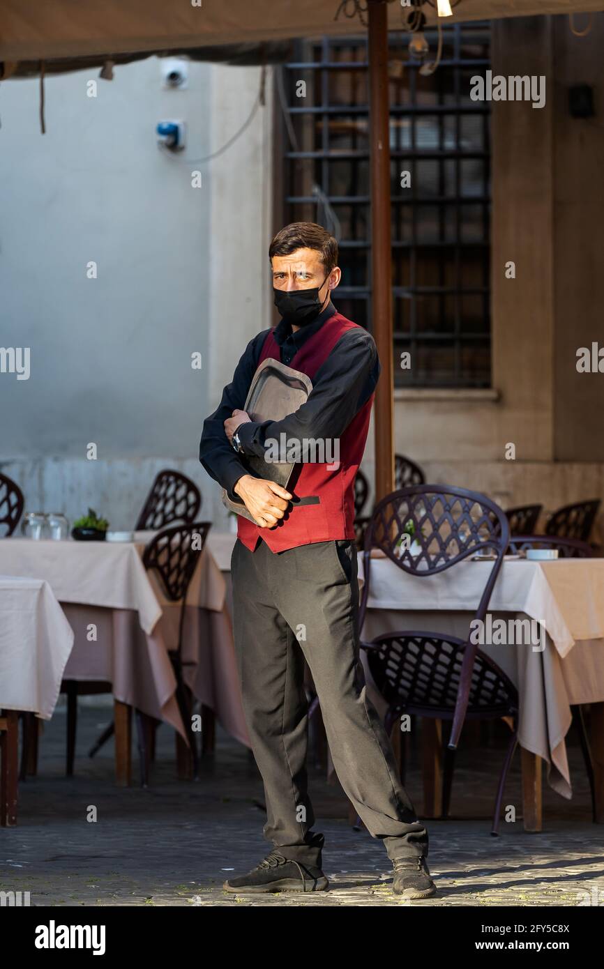 Rome, Italy - May 26, 2021: A waiter waits for customers in the street ...