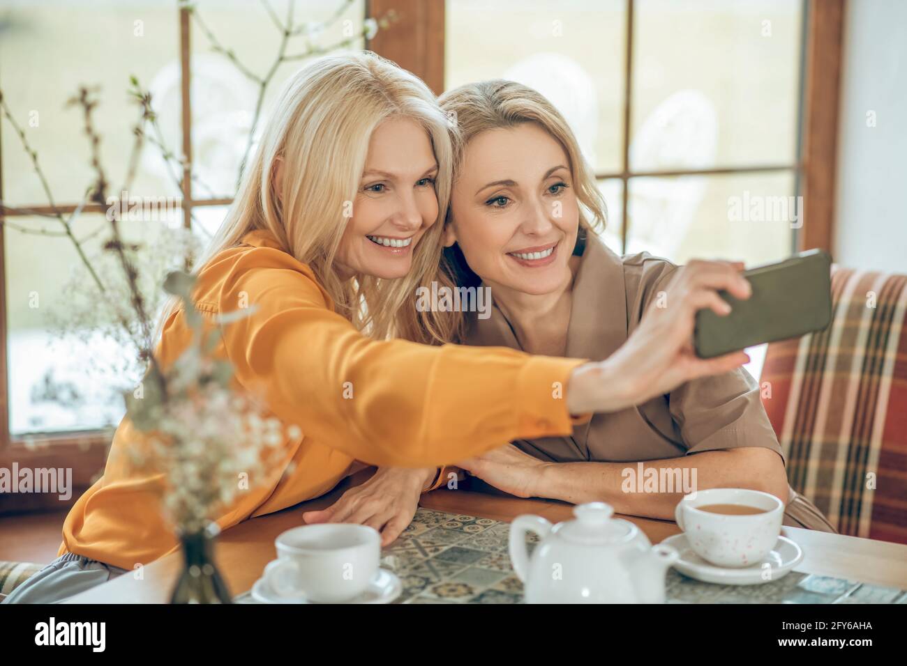 Two cute ladies spending time together and making selfie Stock Photo ...