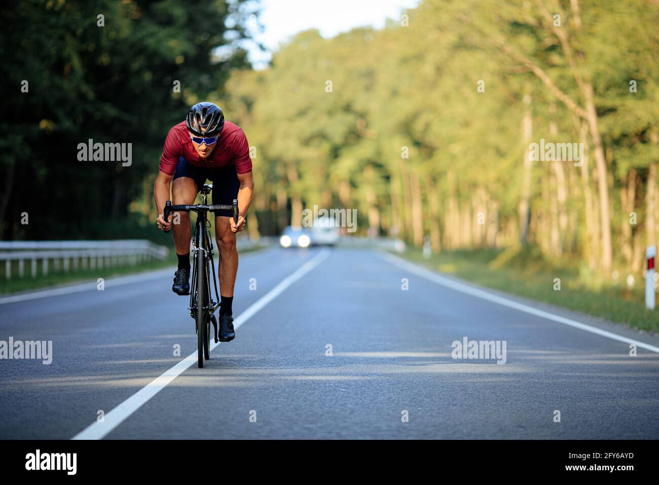 Muscular man actively riding bike on road Stock Photo - Alamy