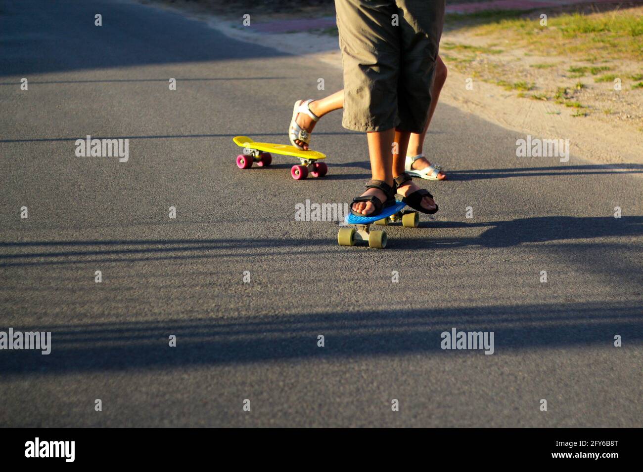 Defocus children playing on skateboard in the street. Caucasian kids ...