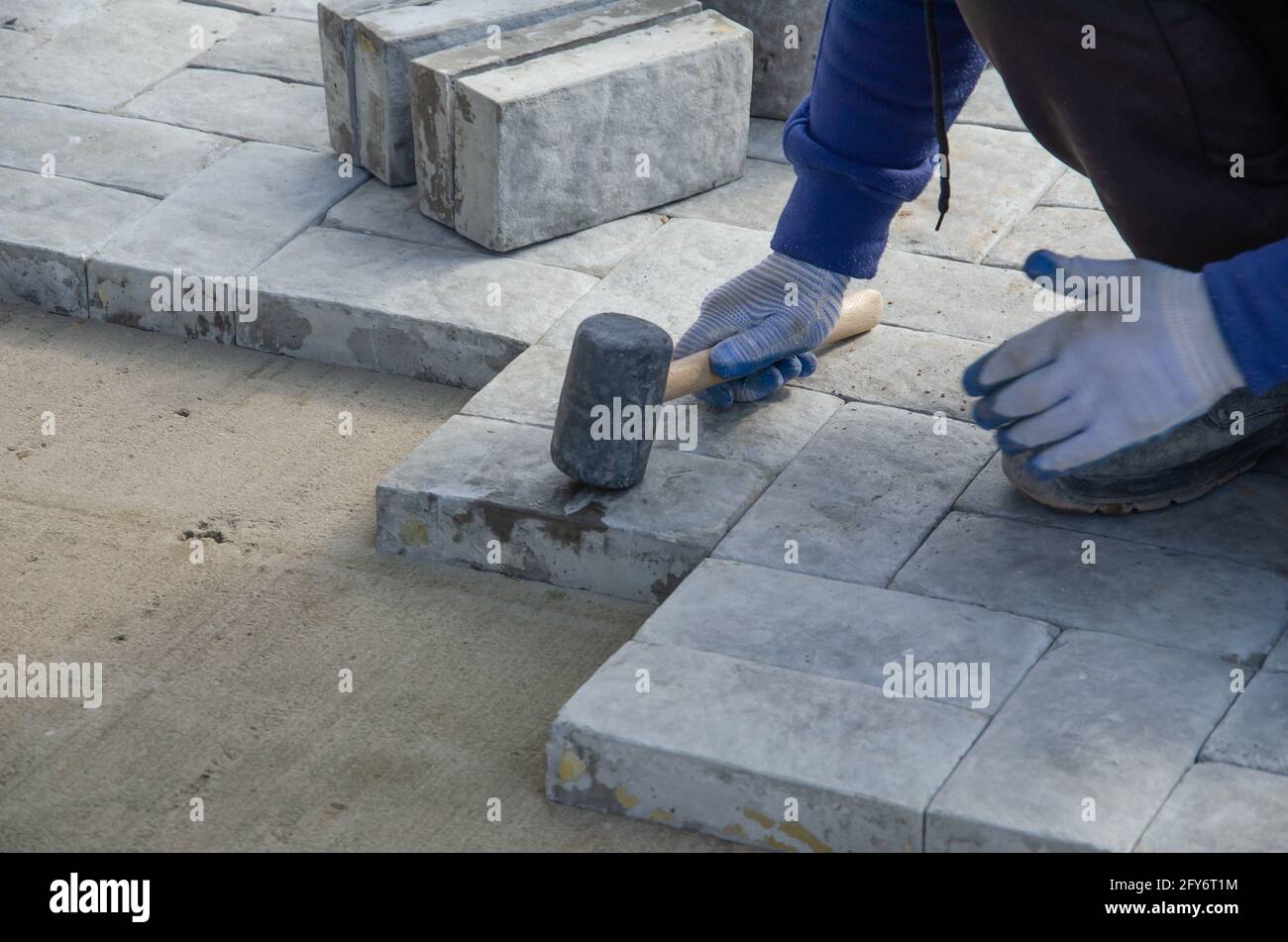 Construction of pavement near the house. Bricklayer places concrete ...