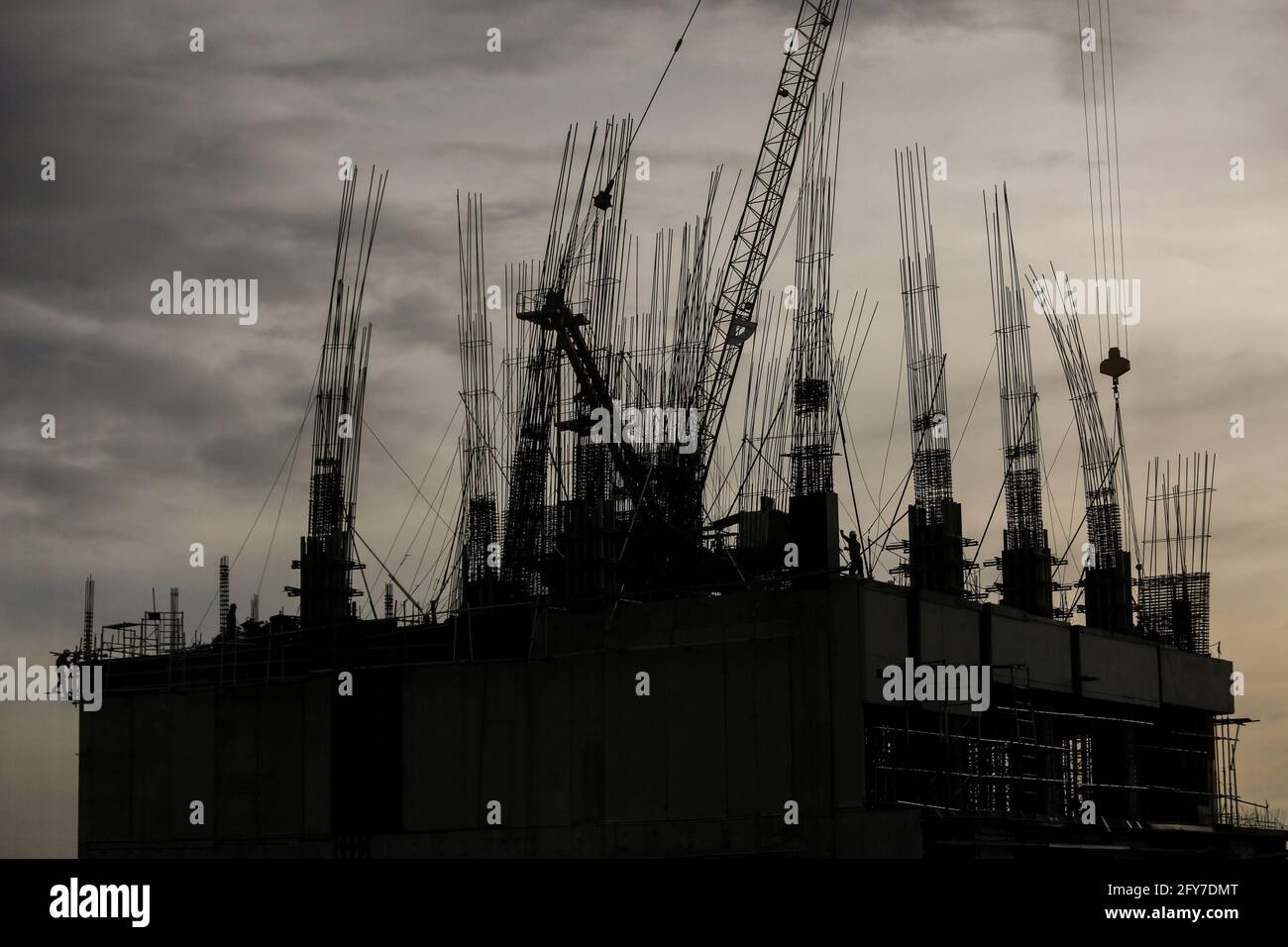 Workers stand on scaffoldings of a building construction site in Manila ...