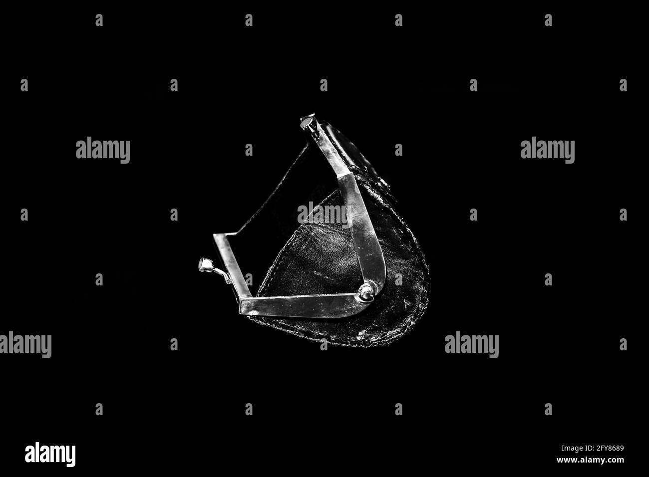 Closeup shot of an empty old coin purse isolated on dark background in ...