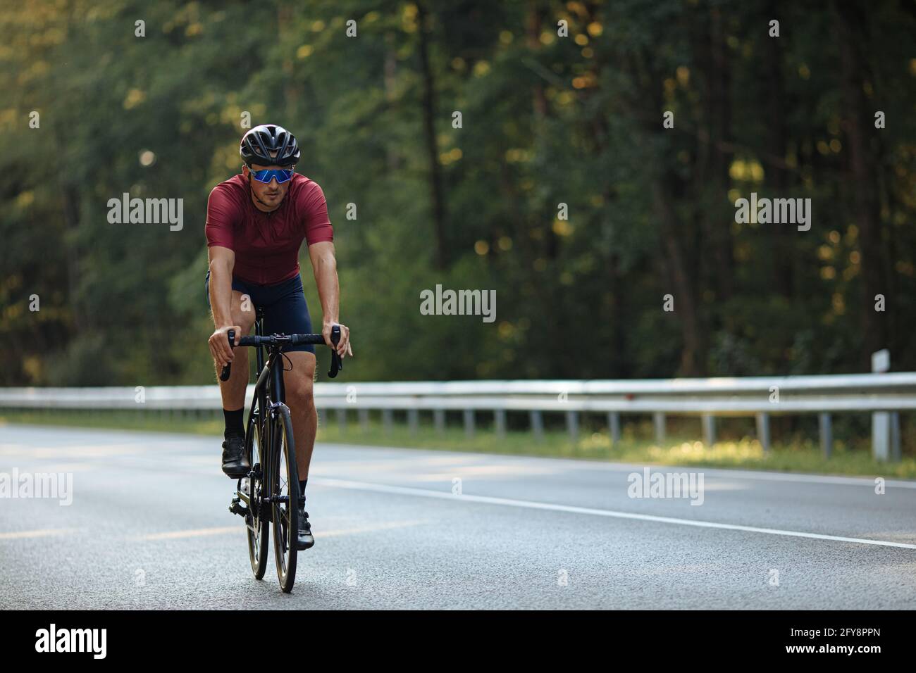 Active cyclist riding bike on paved road Stock Photo - Alamy