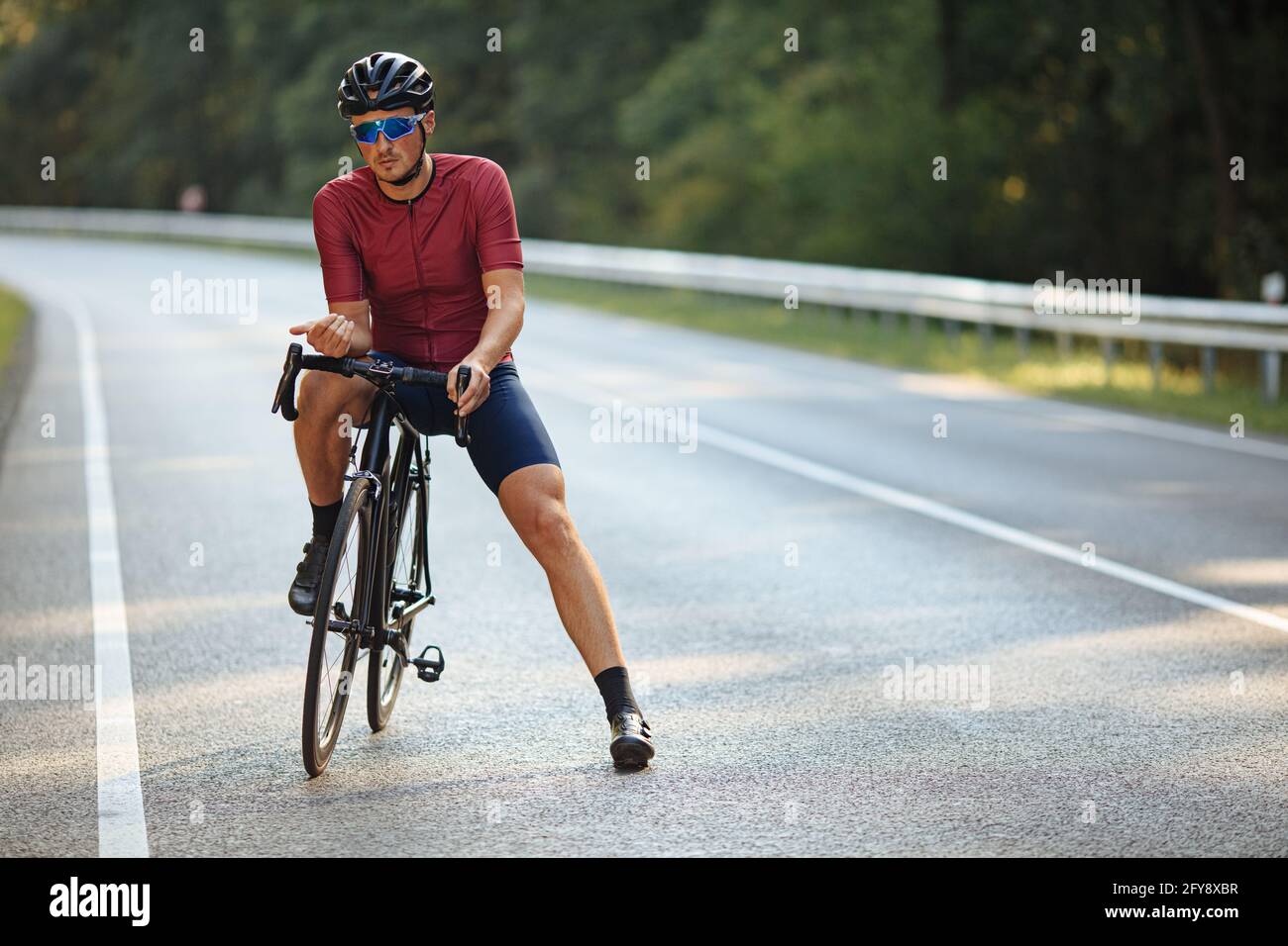 Sportsman sitting on bike while resting outdoors Stock Photo - Alamy