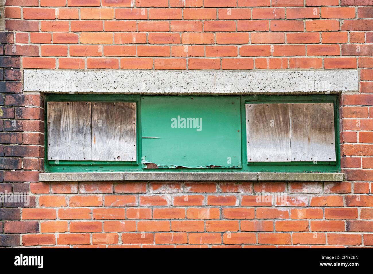 Three boarded up windows set in red brick wall Stock Photo - Alamy