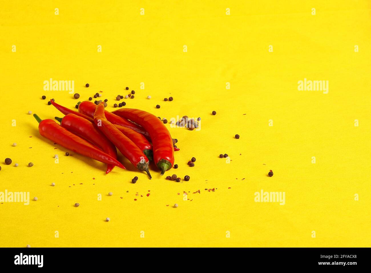 Red hot chilli peppers on a yellow background Stock Photo - Alamy