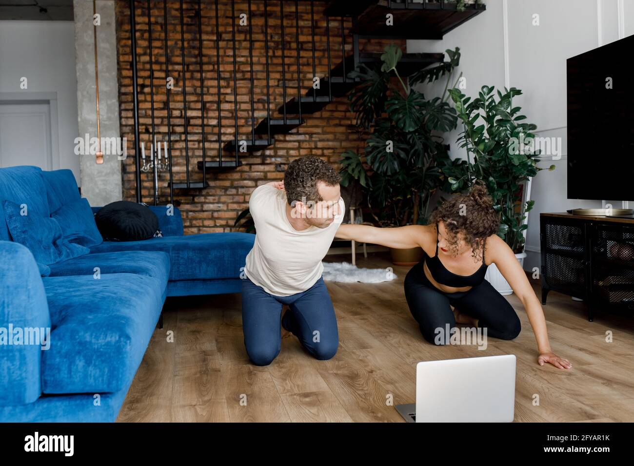 Young Caucasian sporty couple watching live or video tutorial practice ...