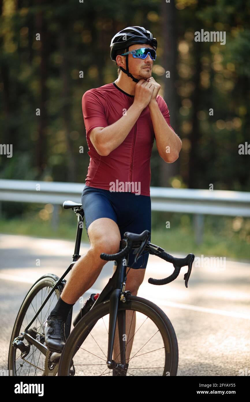 Strong man adjusting helmet before riding bike Stock Photo - Alamy