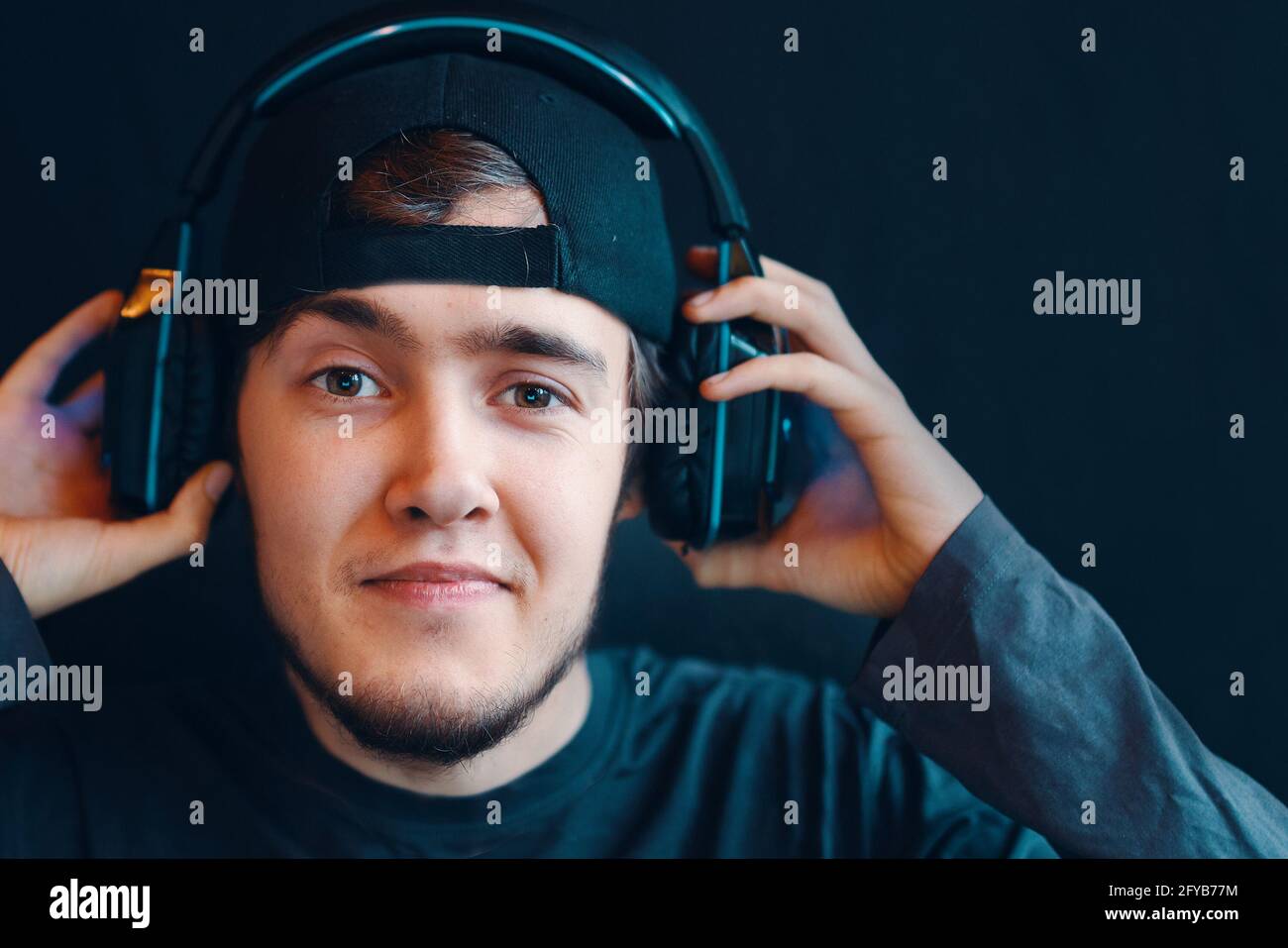 Guy in the cap takes off his headphones. Cyber sport. Young handsome ...