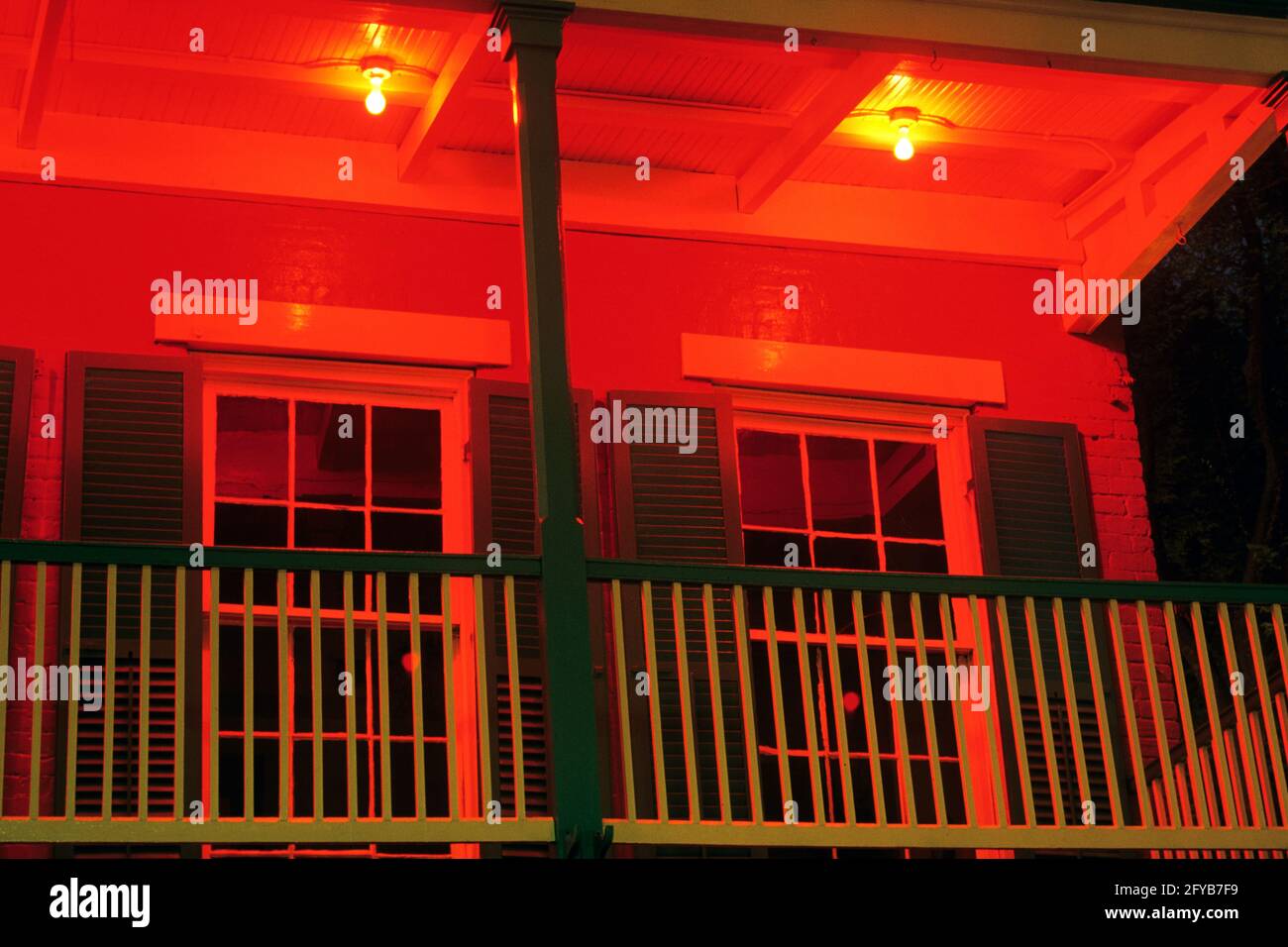 1990s RED FILTER LIGHTS ON UPPER BALCONY PORCH WITH SHUTTERS ON WINDOWS ...