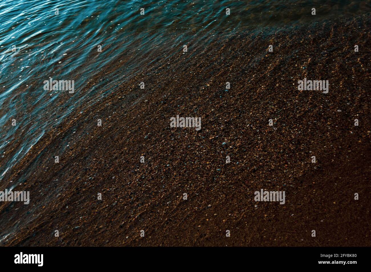 Seashore of sand and shells covered with dark salt water. The theme of ...