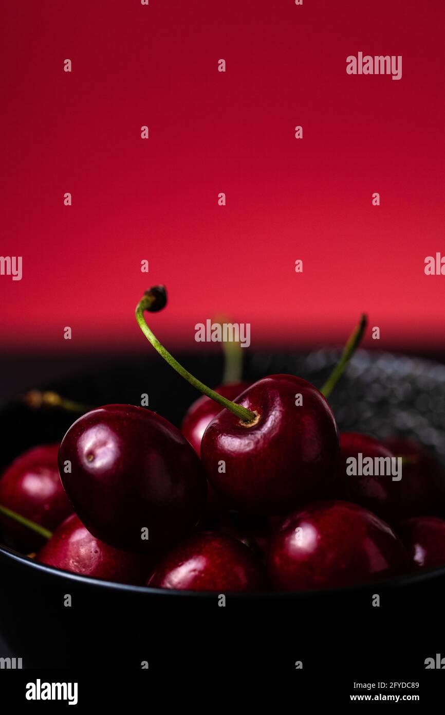 fresh red juicy cherries in a little black bowl Stock Photo - Alamy