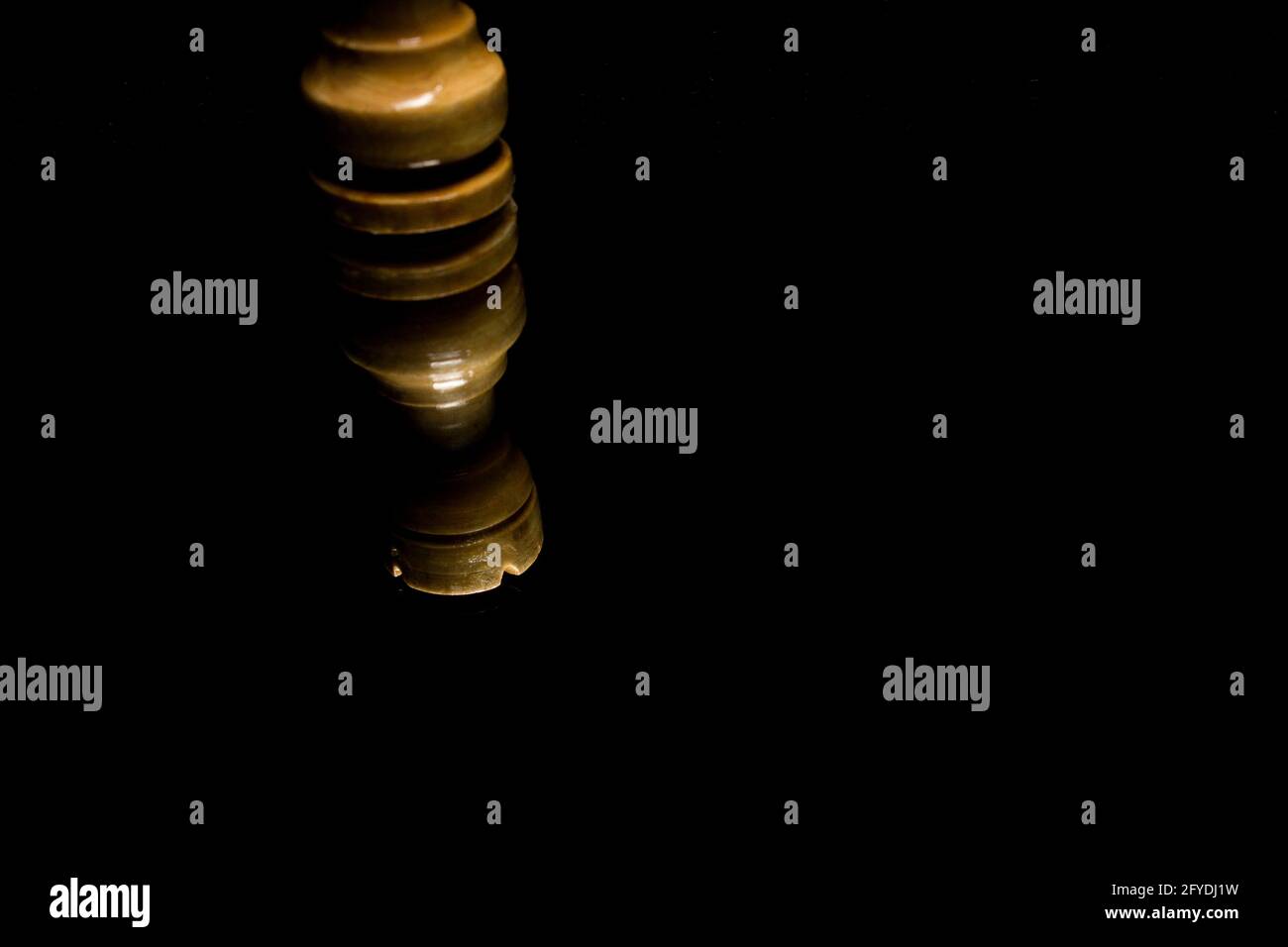 An upside-down reflection of a wooden rook chess piece on black ...