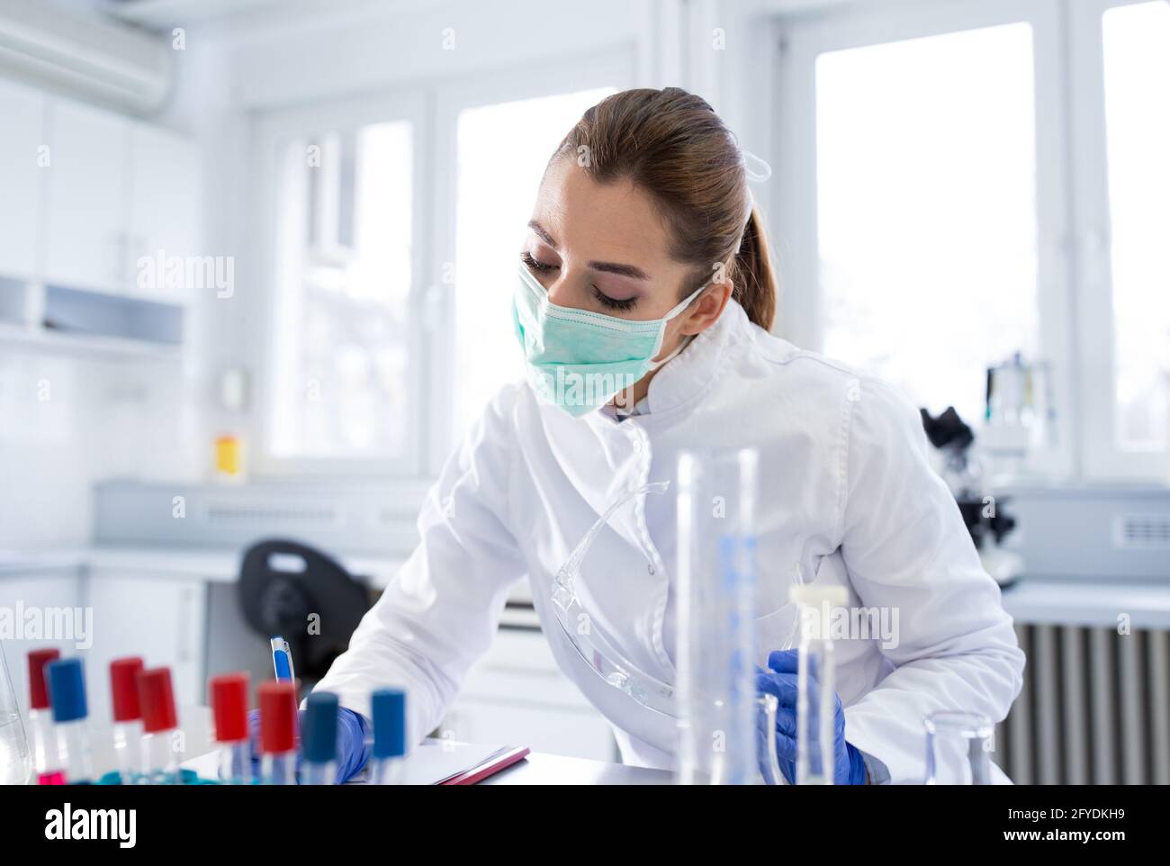 Lab technician working monitoring writing experimenting using vials ...