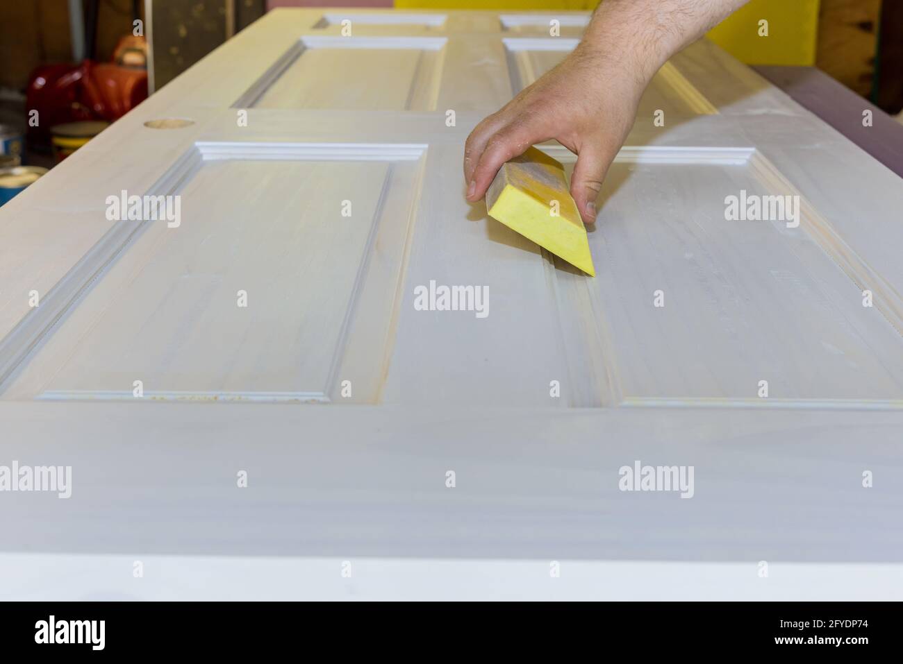 Carpenter in work on worker sanding wooden interior door after primer ...