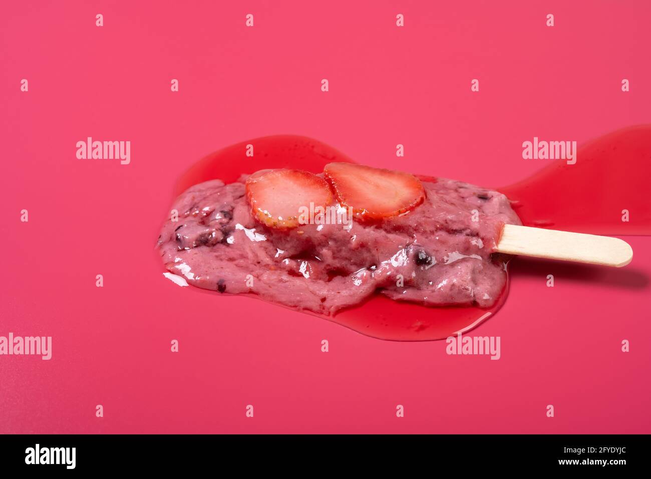 side view half melted Brazil berry flavor popsicle with strawberry ...