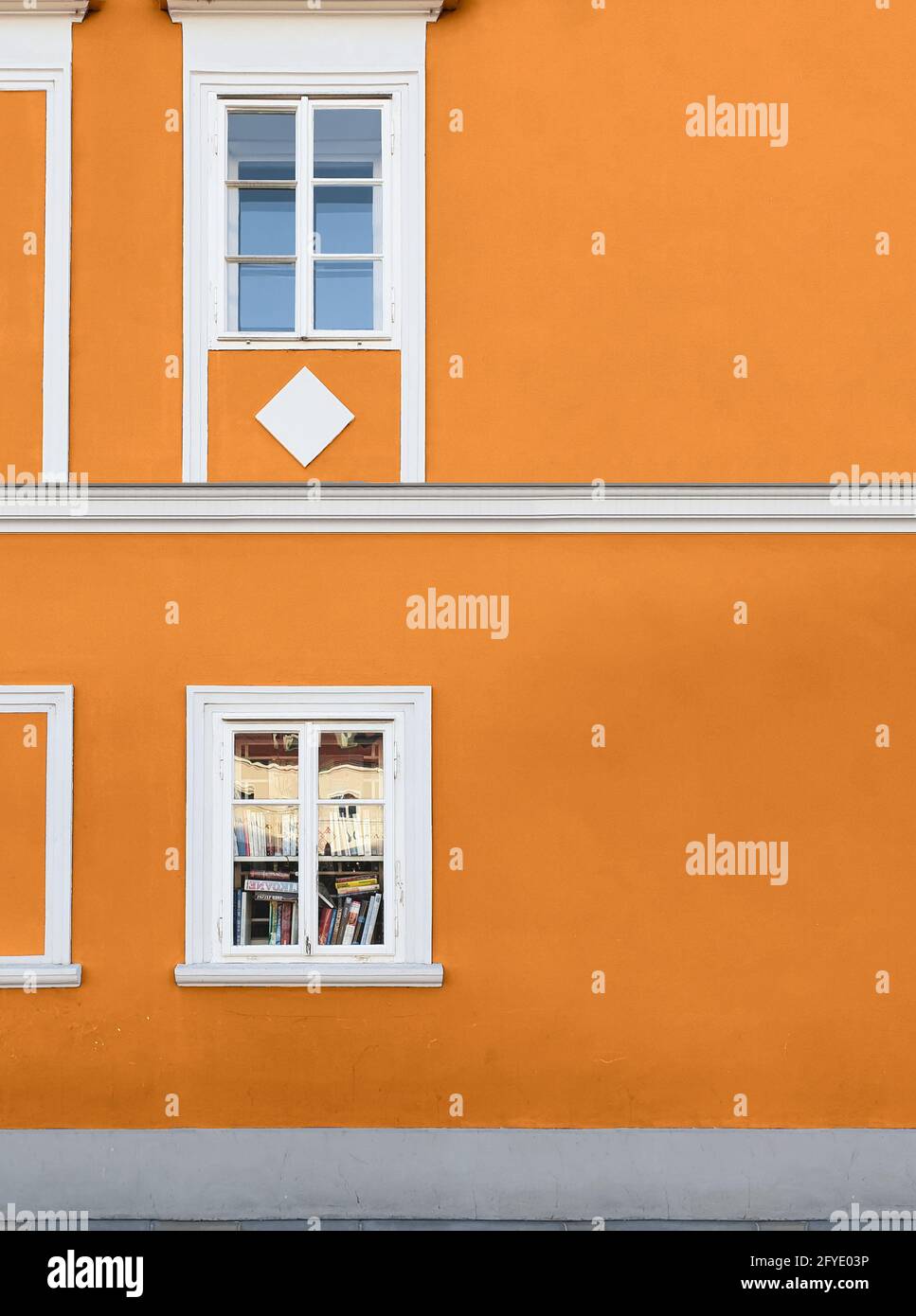 Minimalist image of white window on orange wall of old building Stock ...