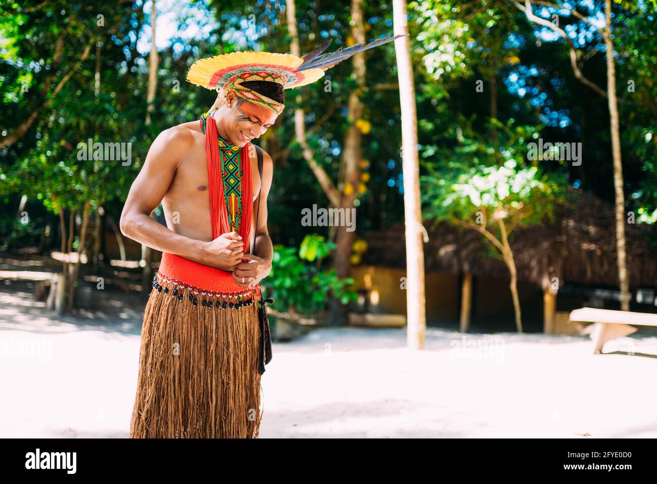 Indian from the Pataxó tribe with feathered headdress looking down and ...