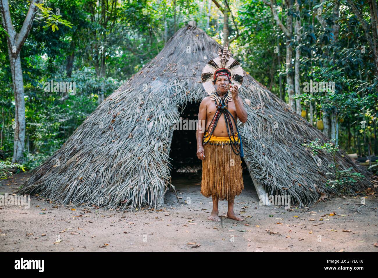 Shaman of the Pataxó tribe, wearing feather headdress and smoking a ...