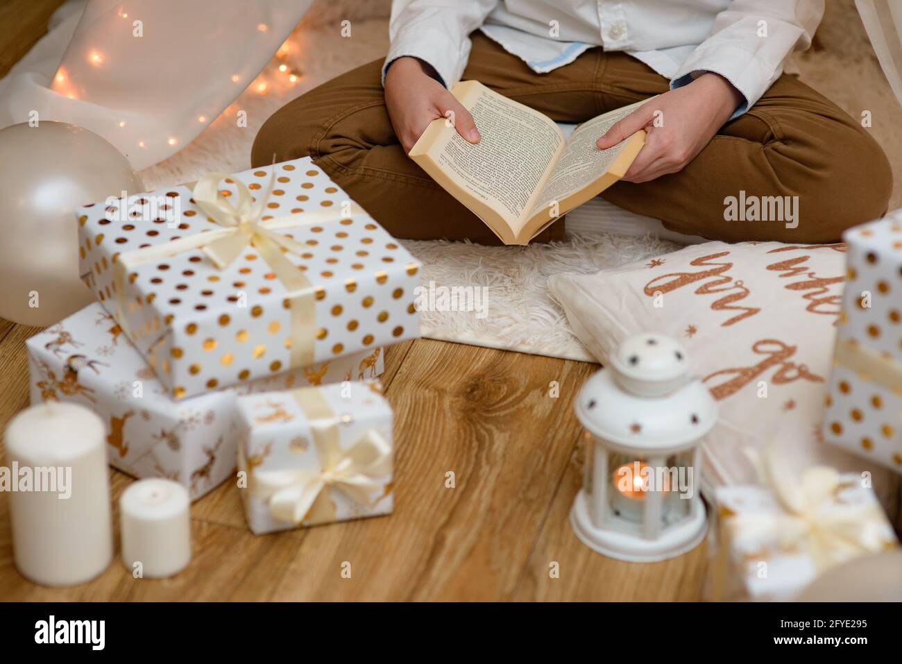 Male reading a book near Christmas decorations Stock Photo - Alamy
