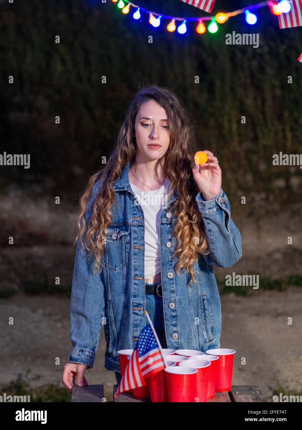 Vertical shot young blonde female playing beer pong Stock Photo - Alamy