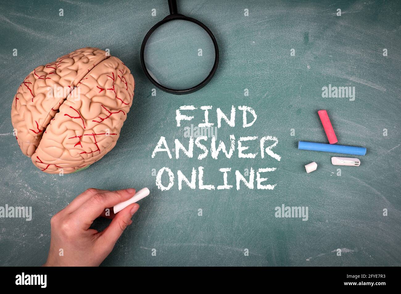 Find answer online. Magnifying glass and pieces of chalk on a green ...