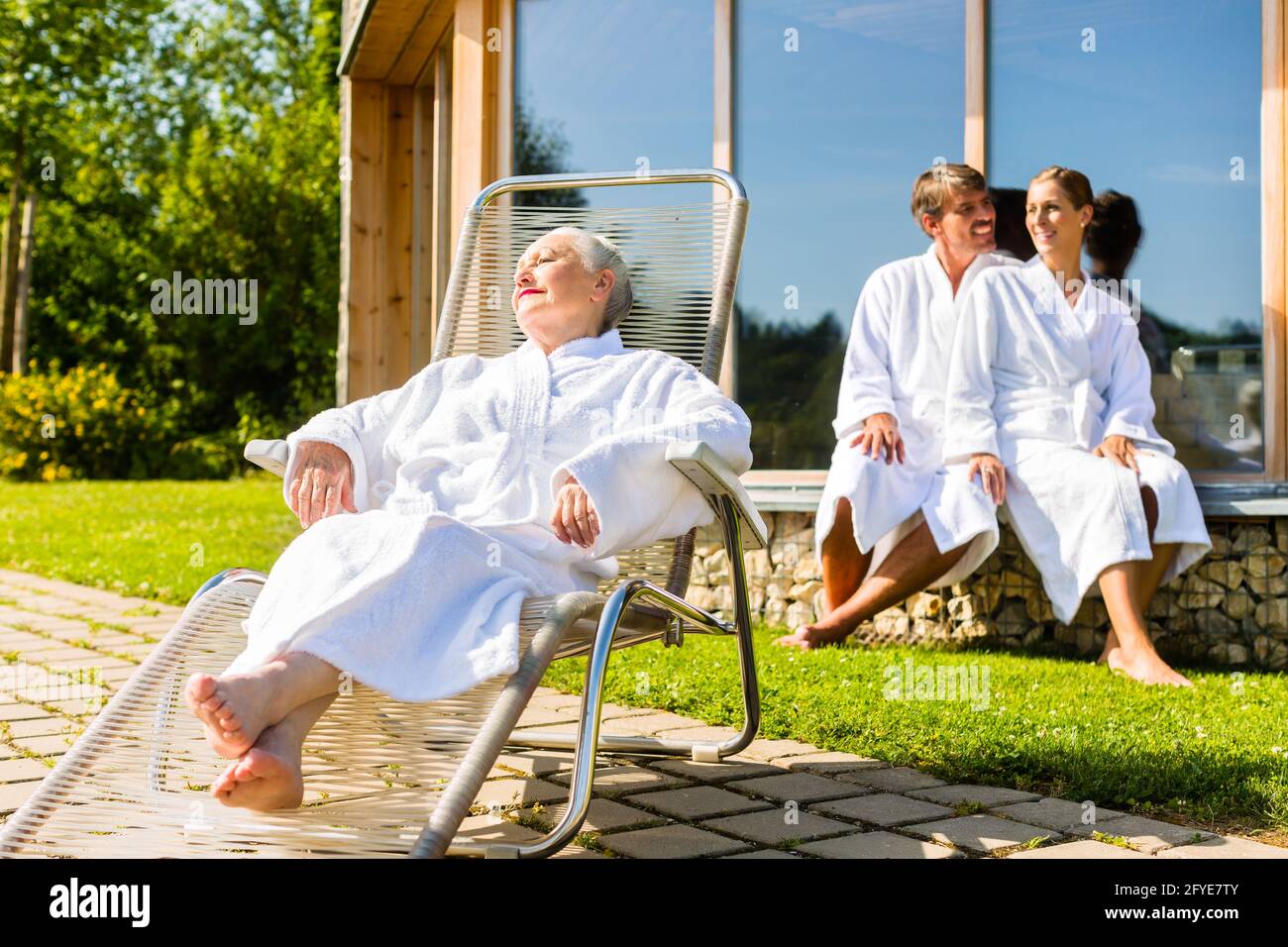 Happy people relaxing on outdoor rest area of sauna Stock Photo - Alamy