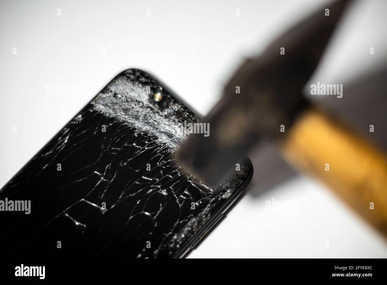 Hammer and smart phone with a broken screen.Electronics repair service ...