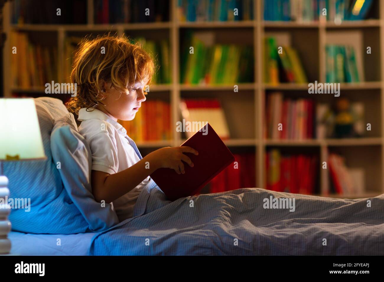 Child reading book in bed. Kids read at night. Little boy with fairy ...
