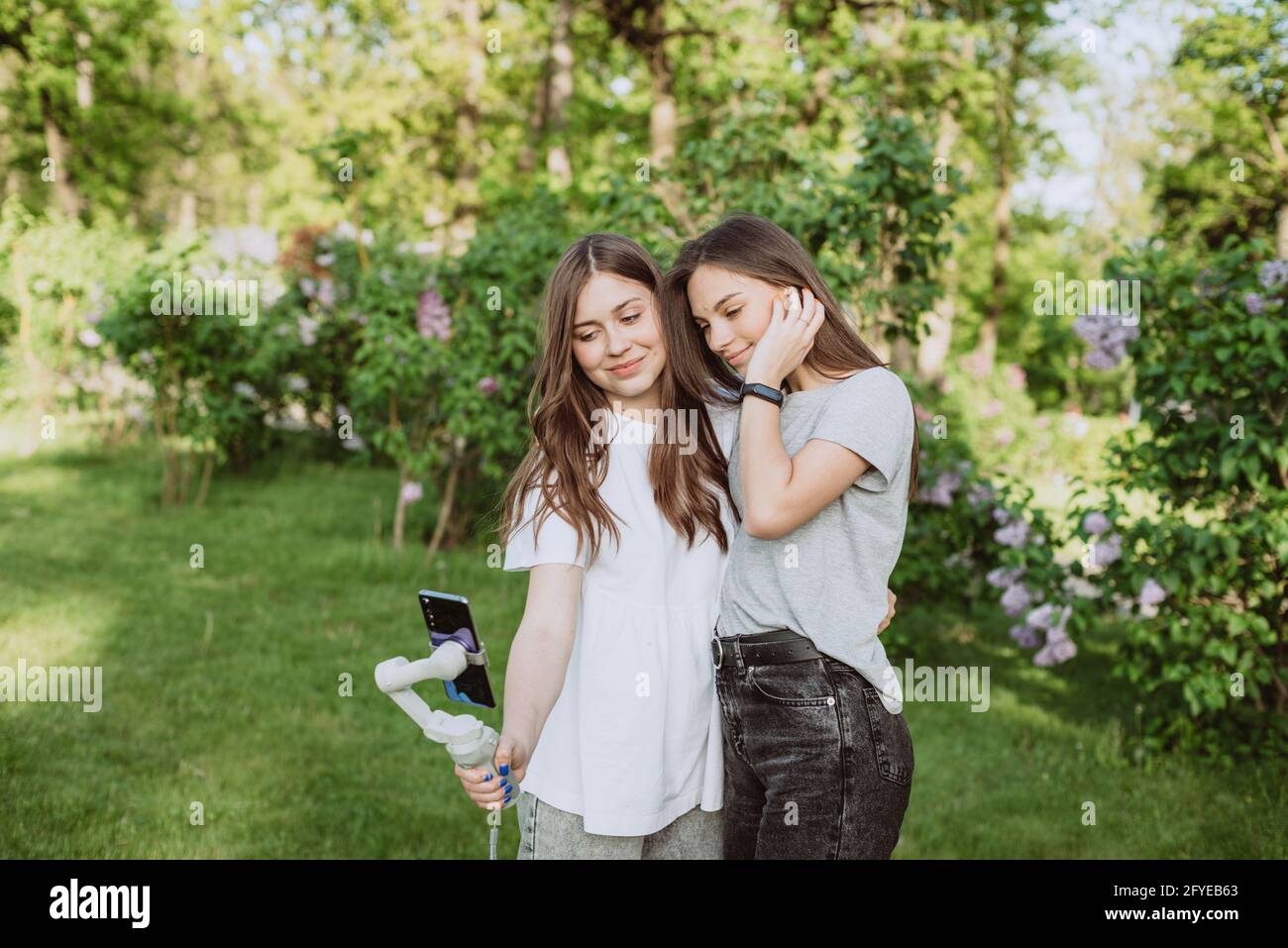 Smiling pretty young women influencer bloggers are filming or recording ...