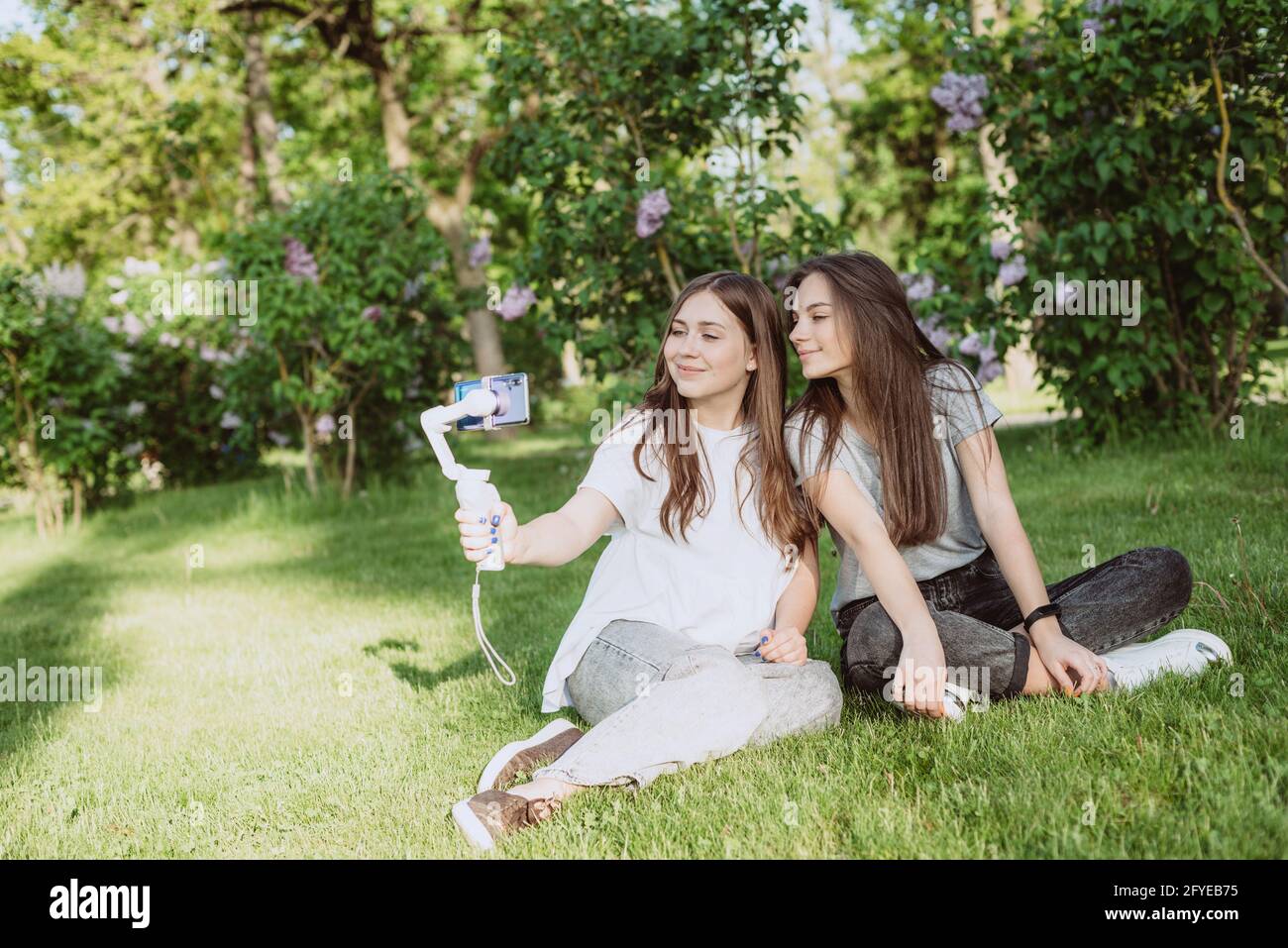 Smiling pretty young women influencer bloggers are filming or recording ...