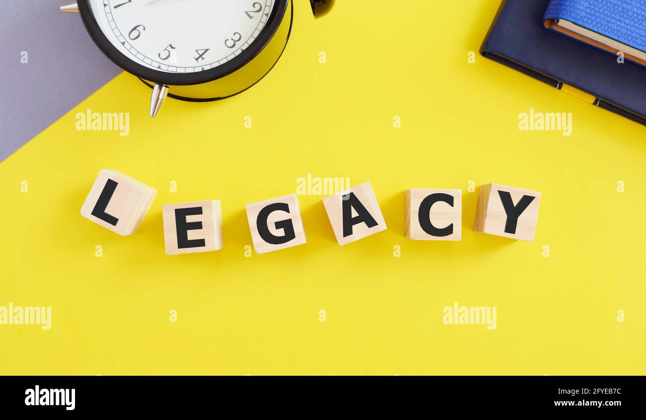 LEGACY word made with building blocks, yellow background,money or ...