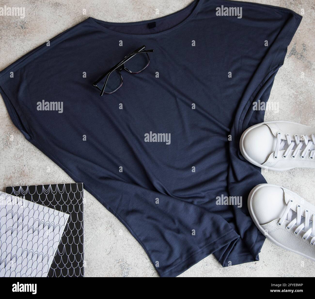 Stylish female clothes set. Woman outfit on concrete background. Blue t ...