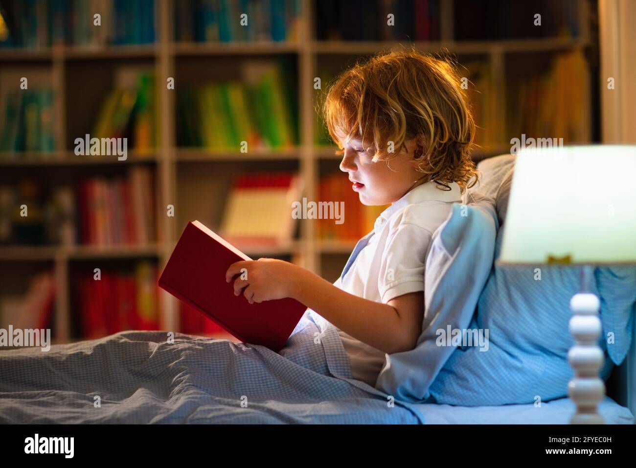 Child reading book in bed. Kids read at night. Little boy with fairy ...