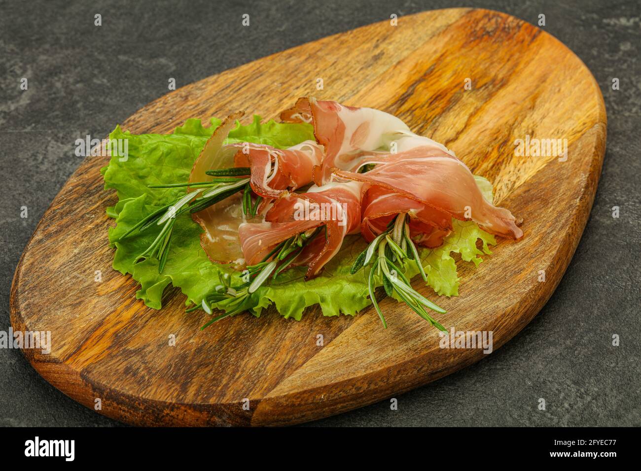 Sliced pork Jamon meat with rosemary Stock Photo - Alamy