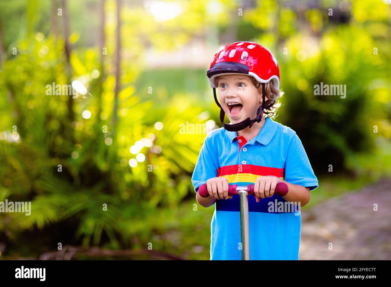 Little boy riding scooter. Kids ride kick board. Child playing on ...