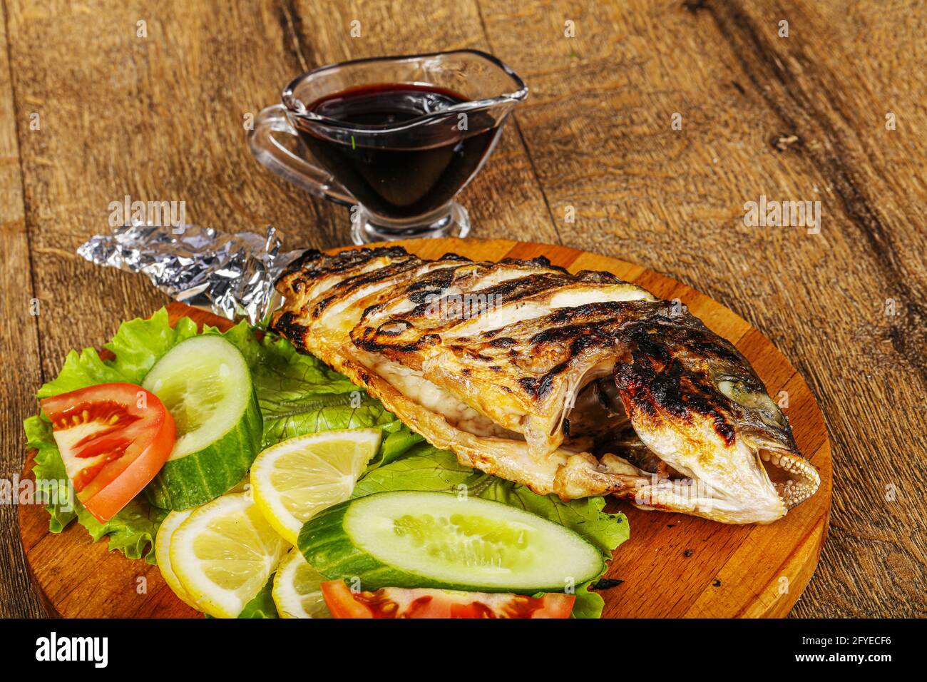 Grilled dorada fish with sauce and vegetables Stock Photo - Alamy