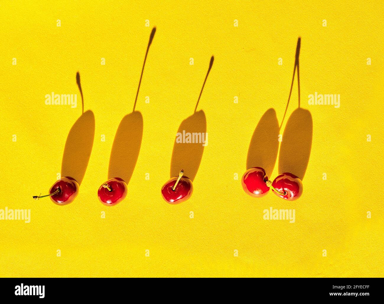 Top view of five red cherries with shadow isolated on a yellow ...