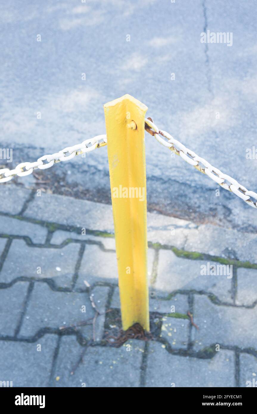 Pole and chain on a sidewalk Stock Photo - Alamy