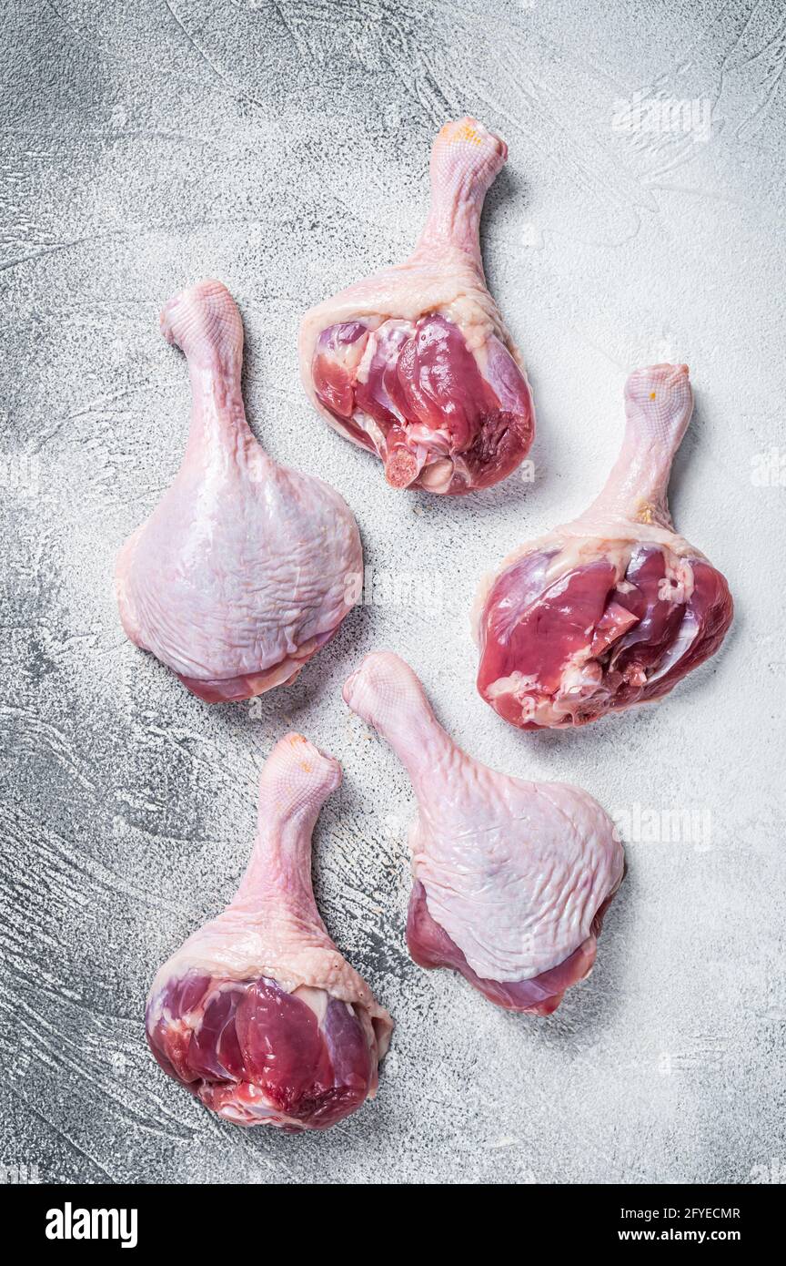 Raw Duck legs drumsticks on butcher table. White background. Top view ...