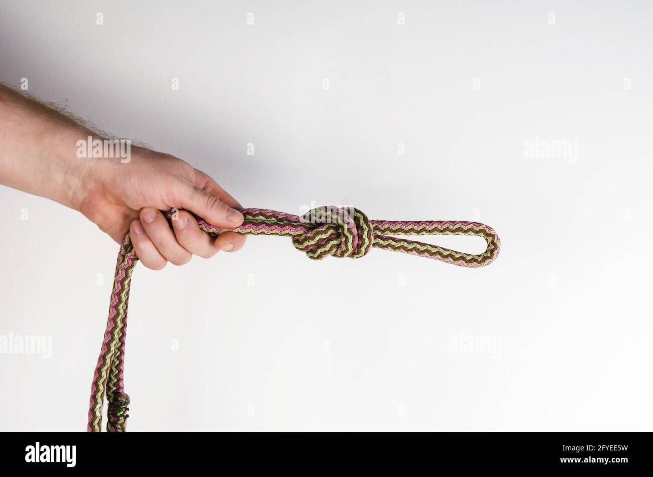 Rope and hand on a white background. Adult male holding a three-color ...