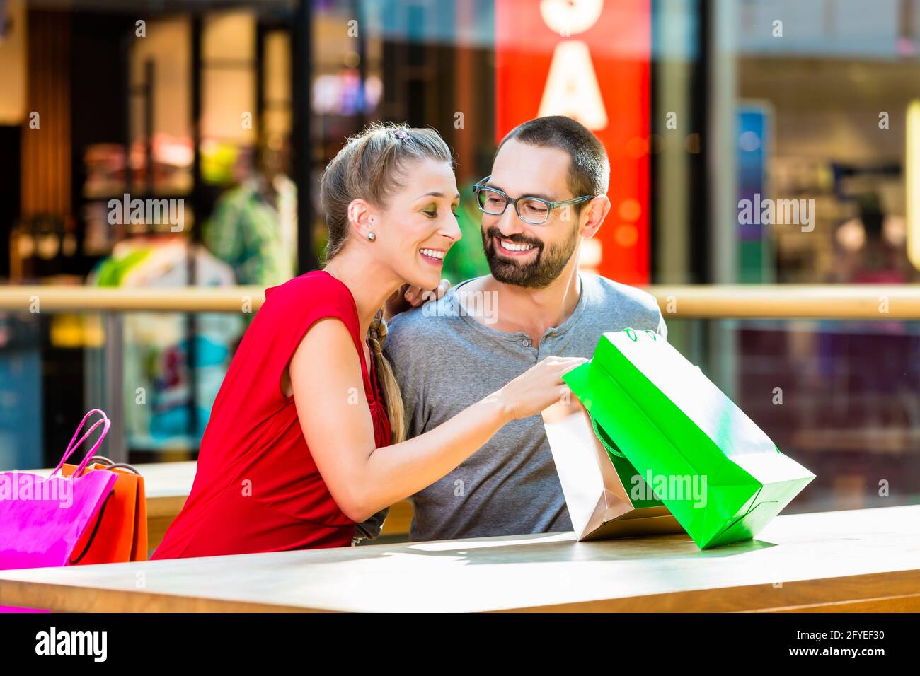 Couple having break from shopping in mall Stock Photo - Alamy