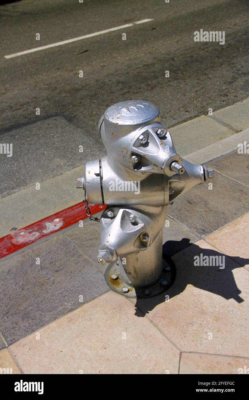 Vertical shot of a fire hydrant on the street casting a small shadow ...