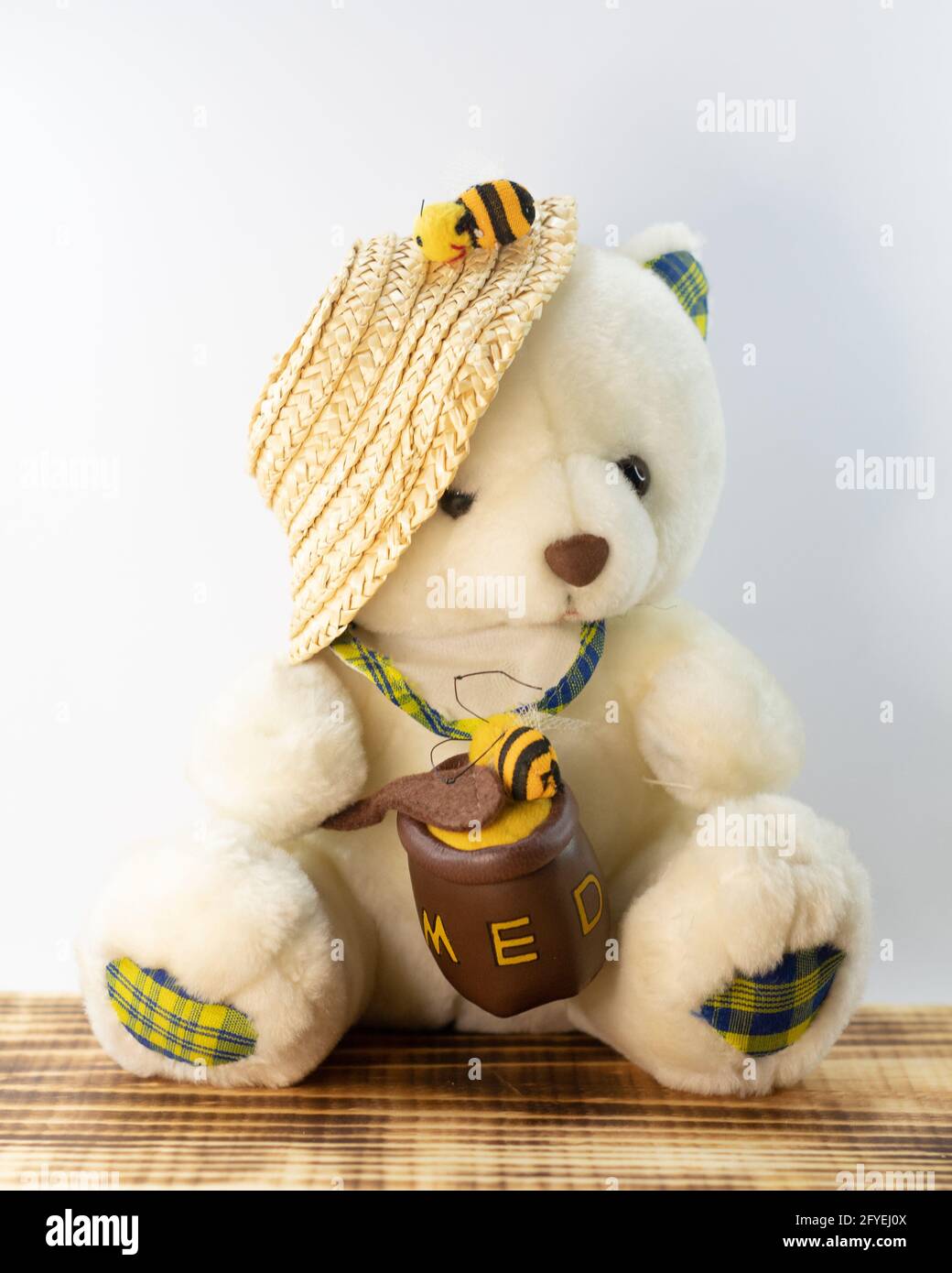 Shot of the teddy bear on a wooden base with a white plain background ...