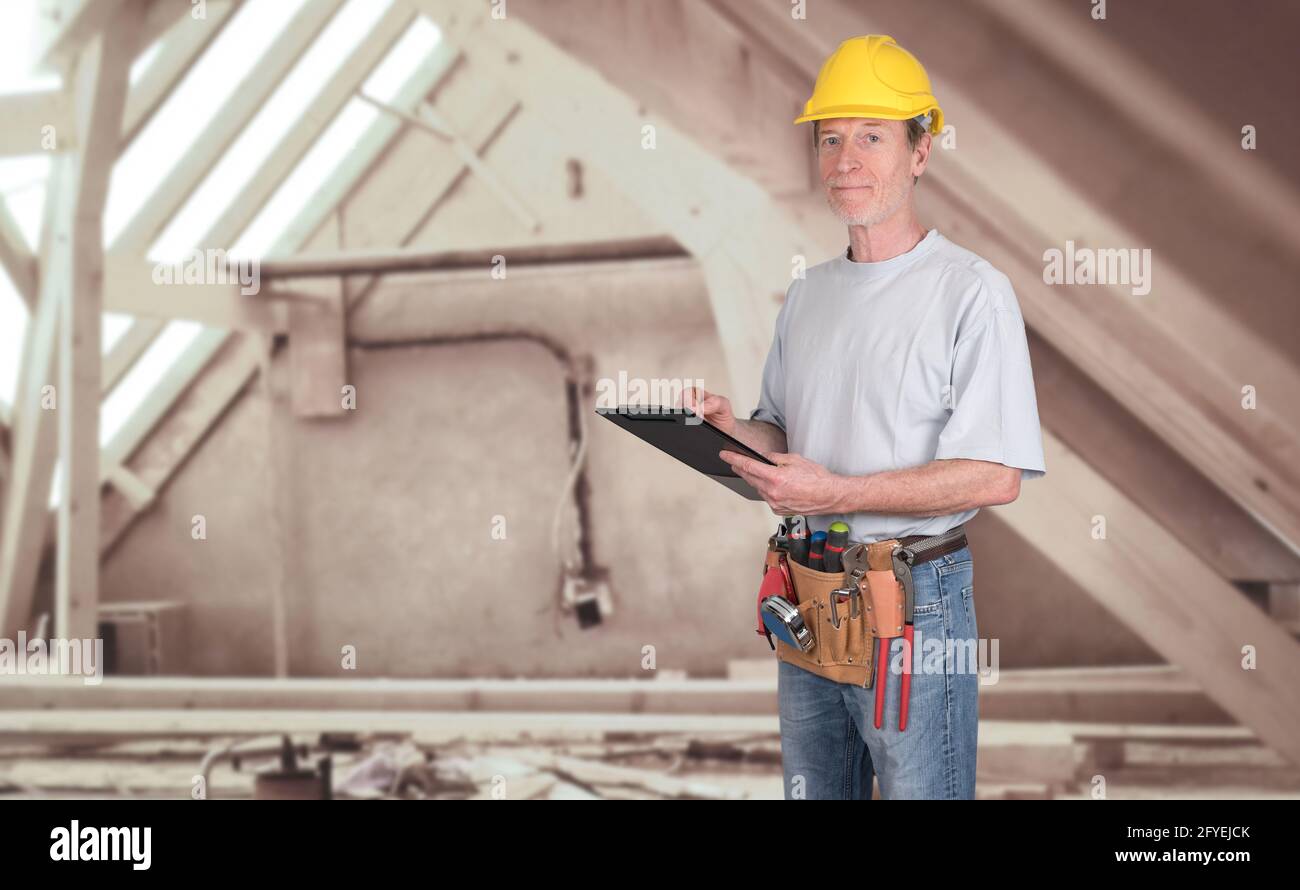 Building worker with tool belt taking notes on a construction site ...