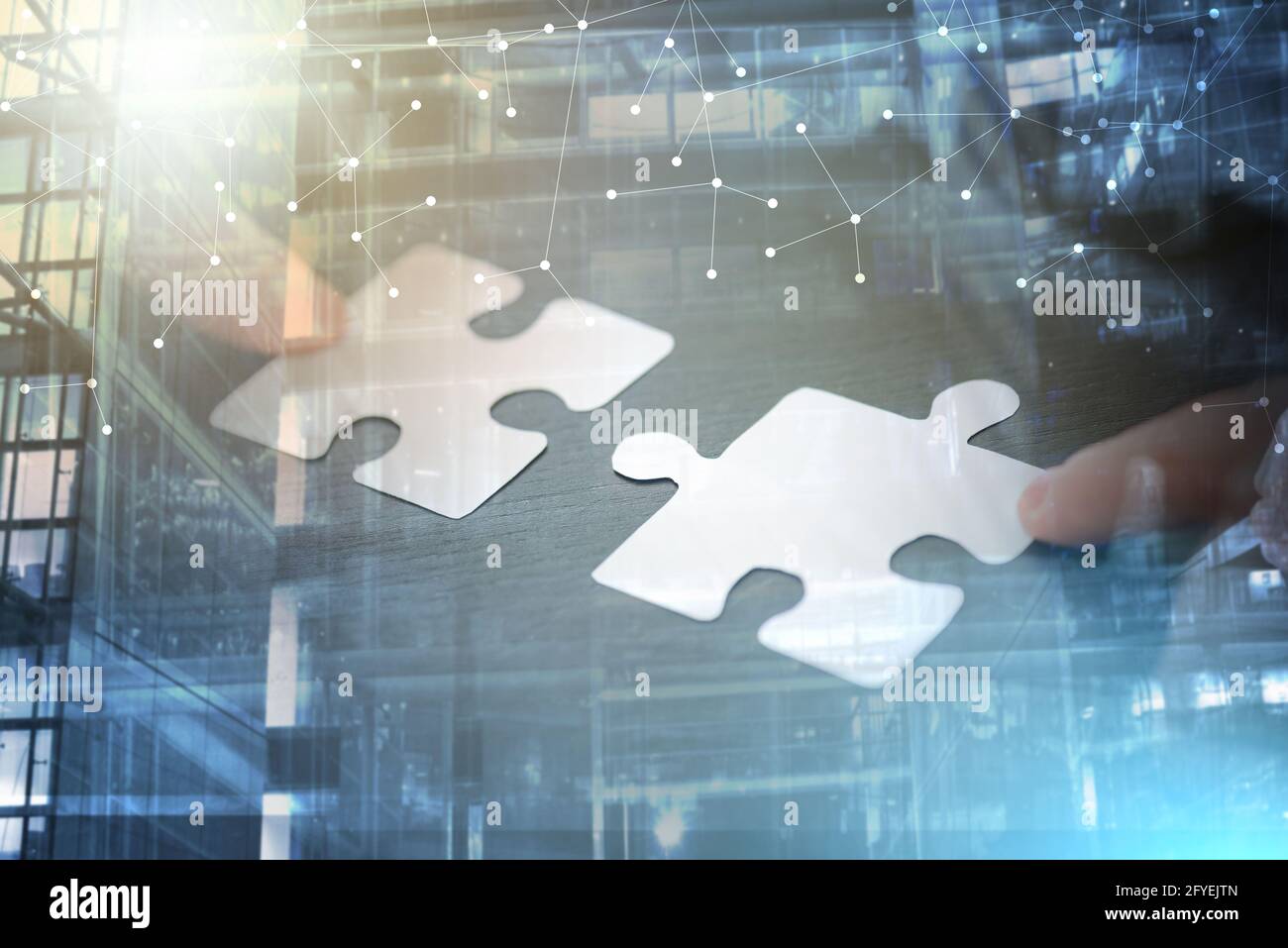 Hands joining two puzzle pieces, teamwork concept; multiple exposure ...