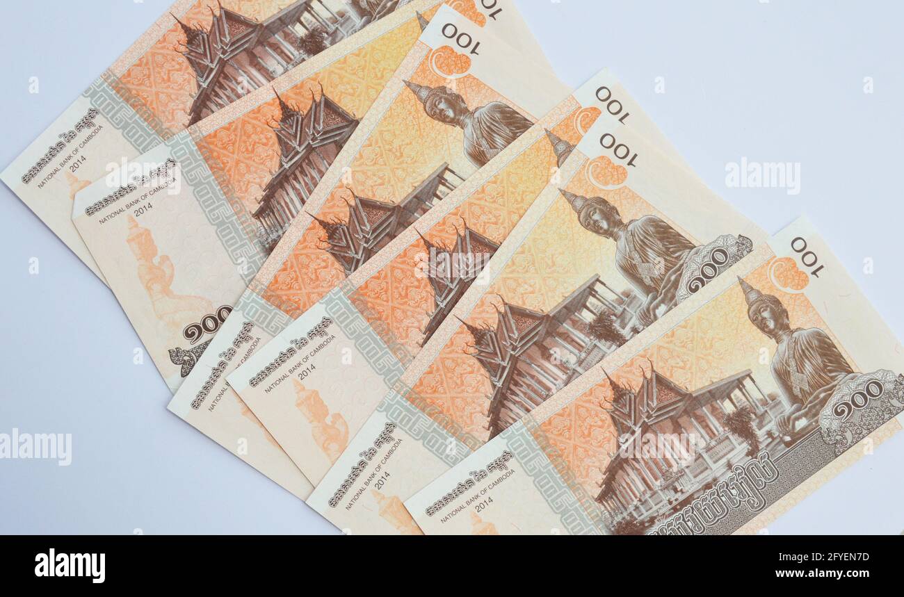 Multiple 100 riel, Cambodia currency spread out on white background ...